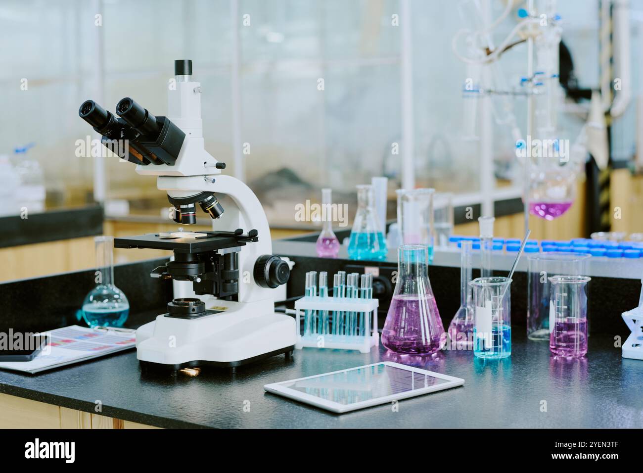 Modern laboratory featuring microscope surrounded by beakers, test ...