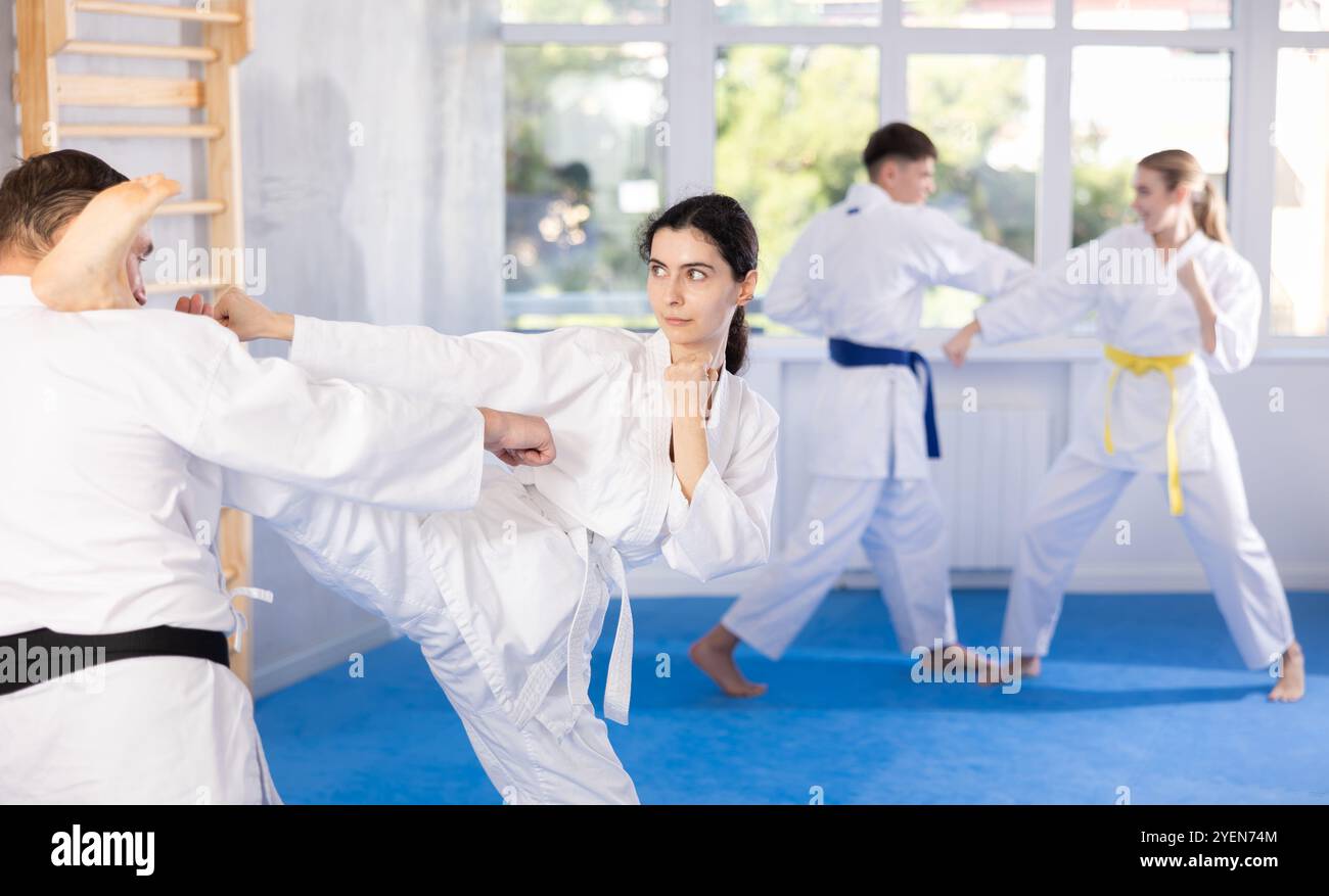 arate trainer helps woman learn how to kick during karate training ...