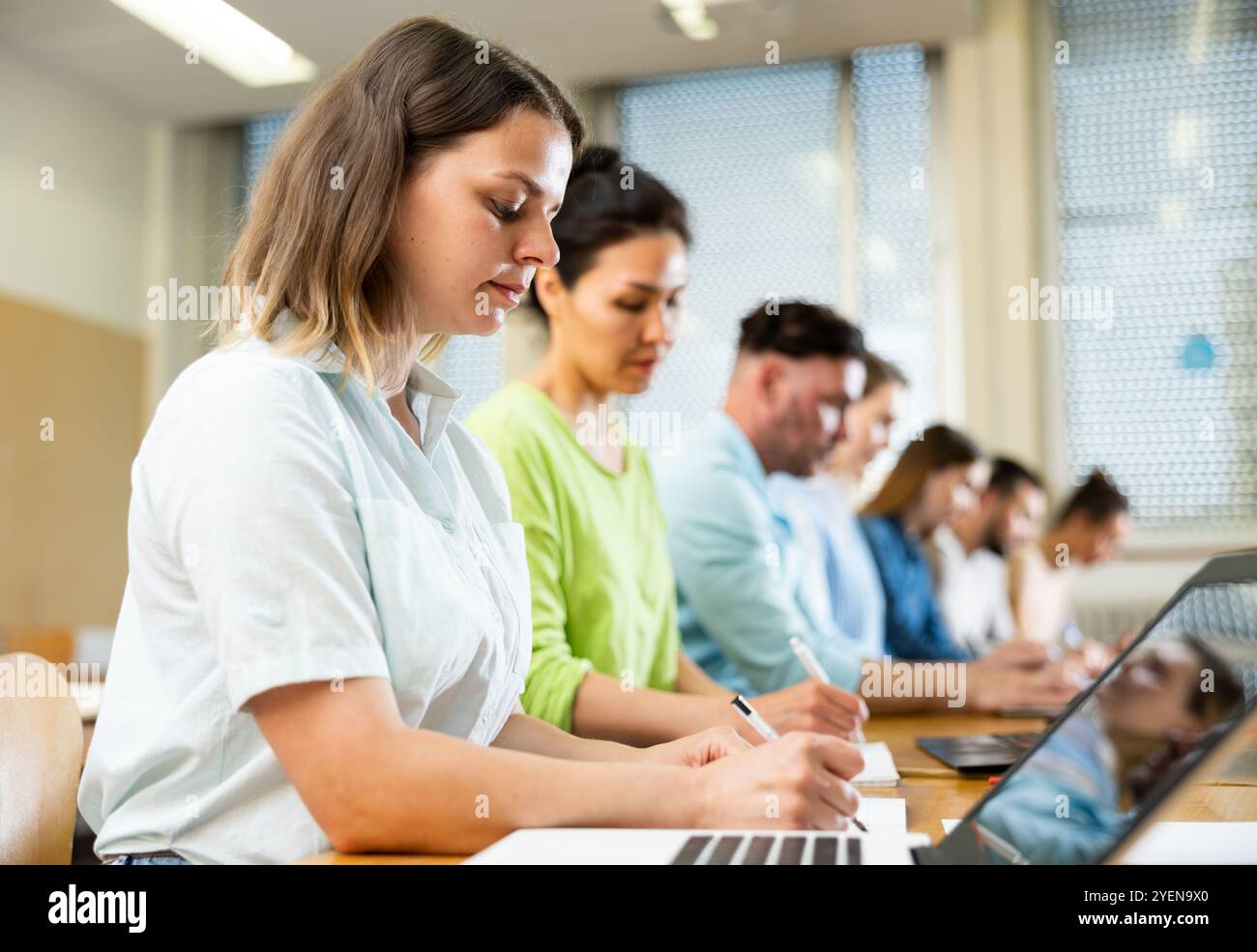Woman university student writing in classroom Stock Photo - Alamy