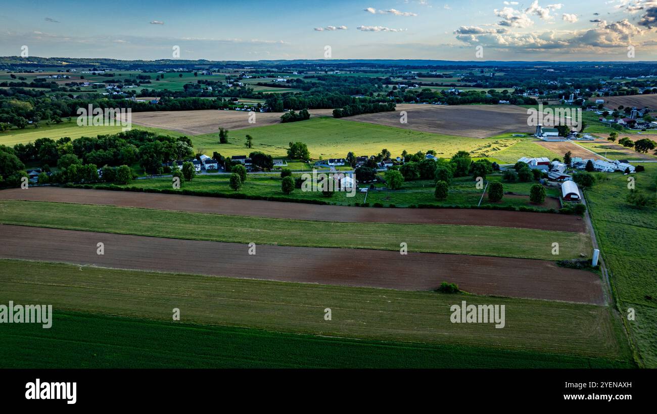 The landscape showcases expansive farmland with vibrant fields, quaint ...