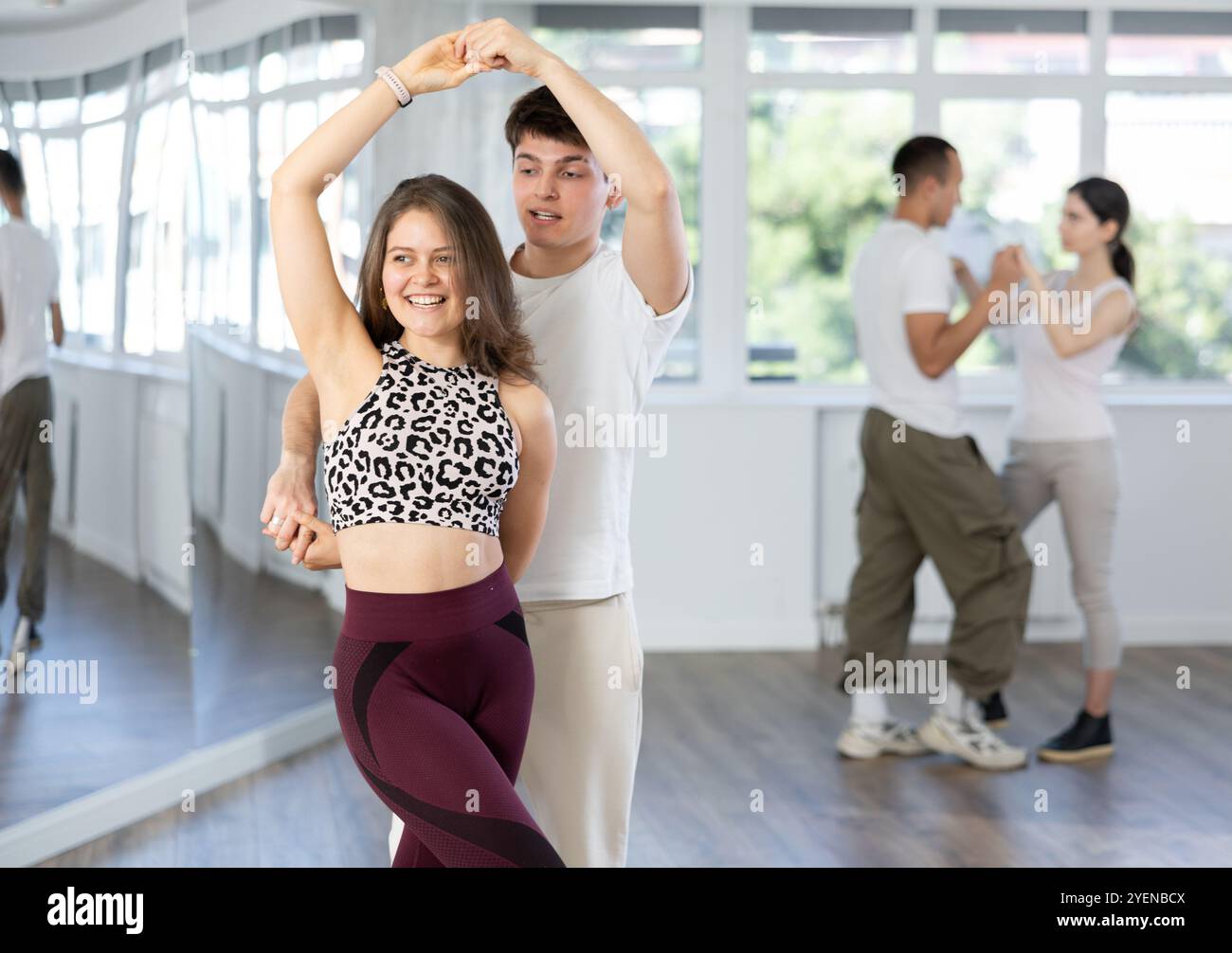 Girl paired up with young man, they train to perform slow waltz dance ...