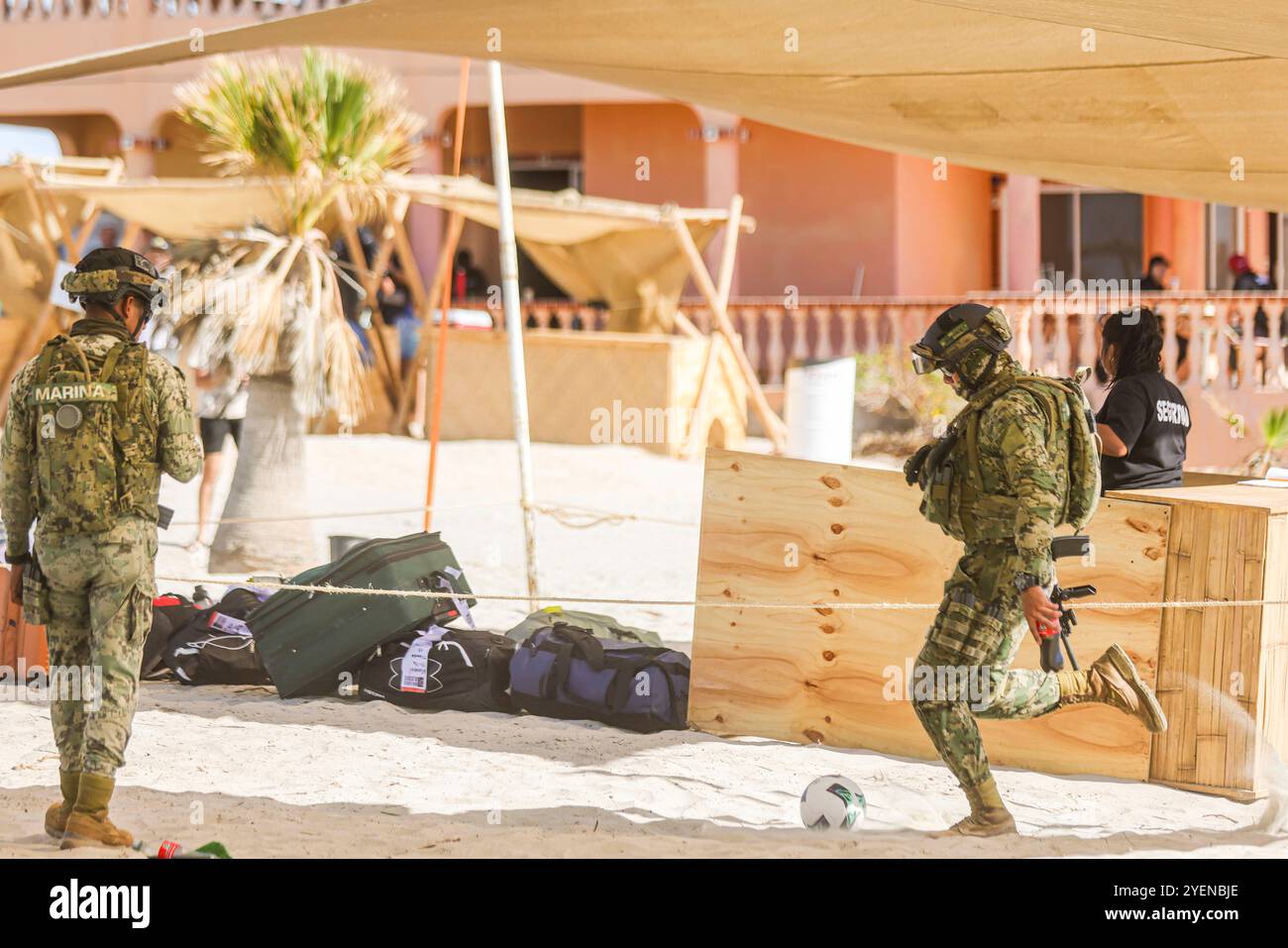 Mexican Army and Navy soldiers kick a soccer ball as they watch the ...