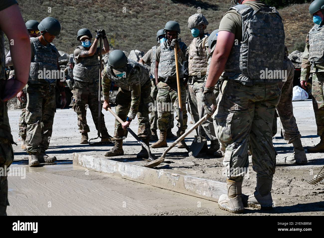 A group of Civil Engineer Squadron members smooth concrete during a ...