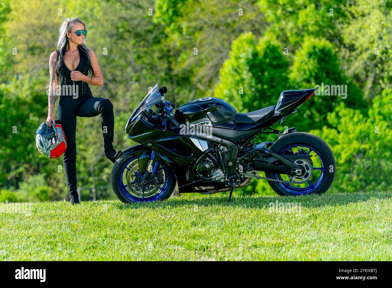 A stunning woman strikes a confident pose beside her high-performance ...