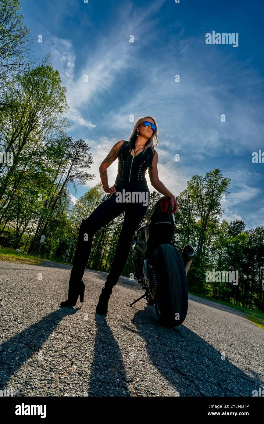 A stunning woman strikes a confident pose beside her high-performance ...