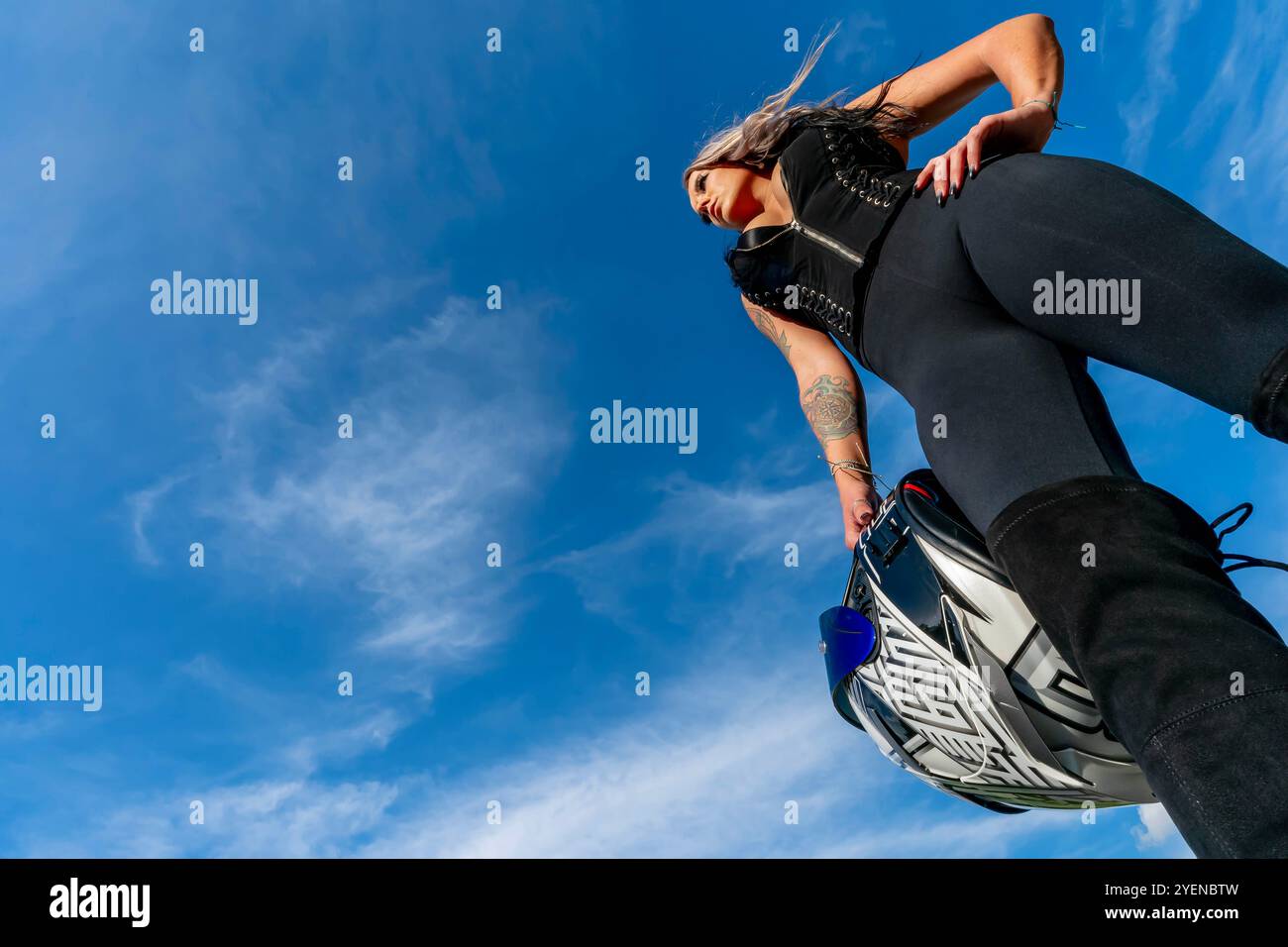 A stunning woman strikes a confident pose beside her high-performance ...