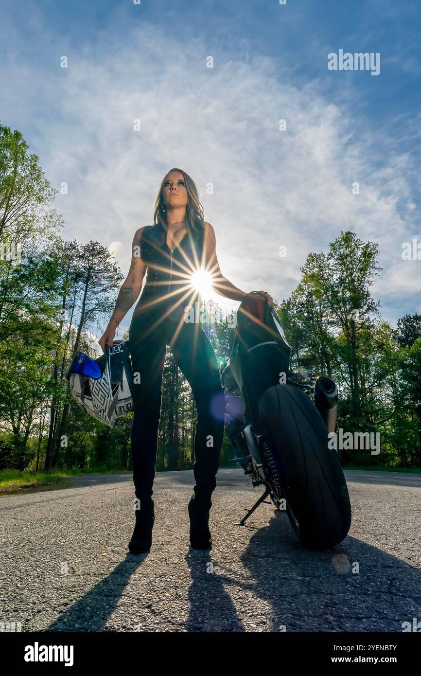 A stunning woman strikes a confident pose beside her high-performance ...