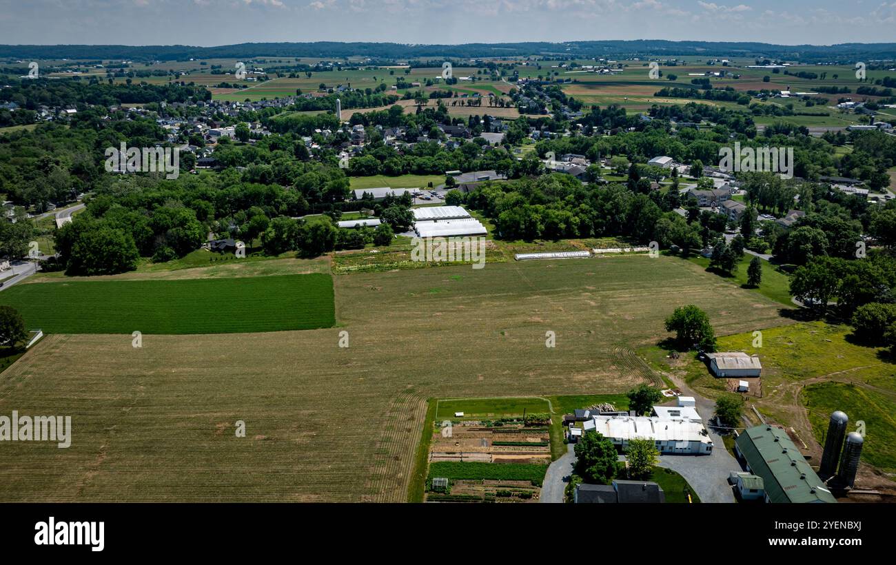An expansive aerial view captures the lush green fields and patches of ...