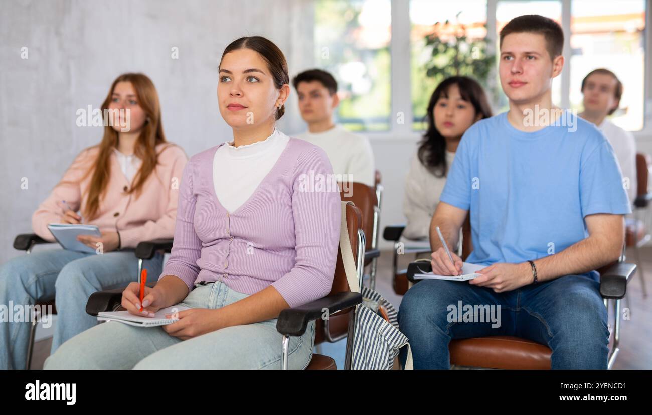 High school students sit at their desks and listen carefully to the ...