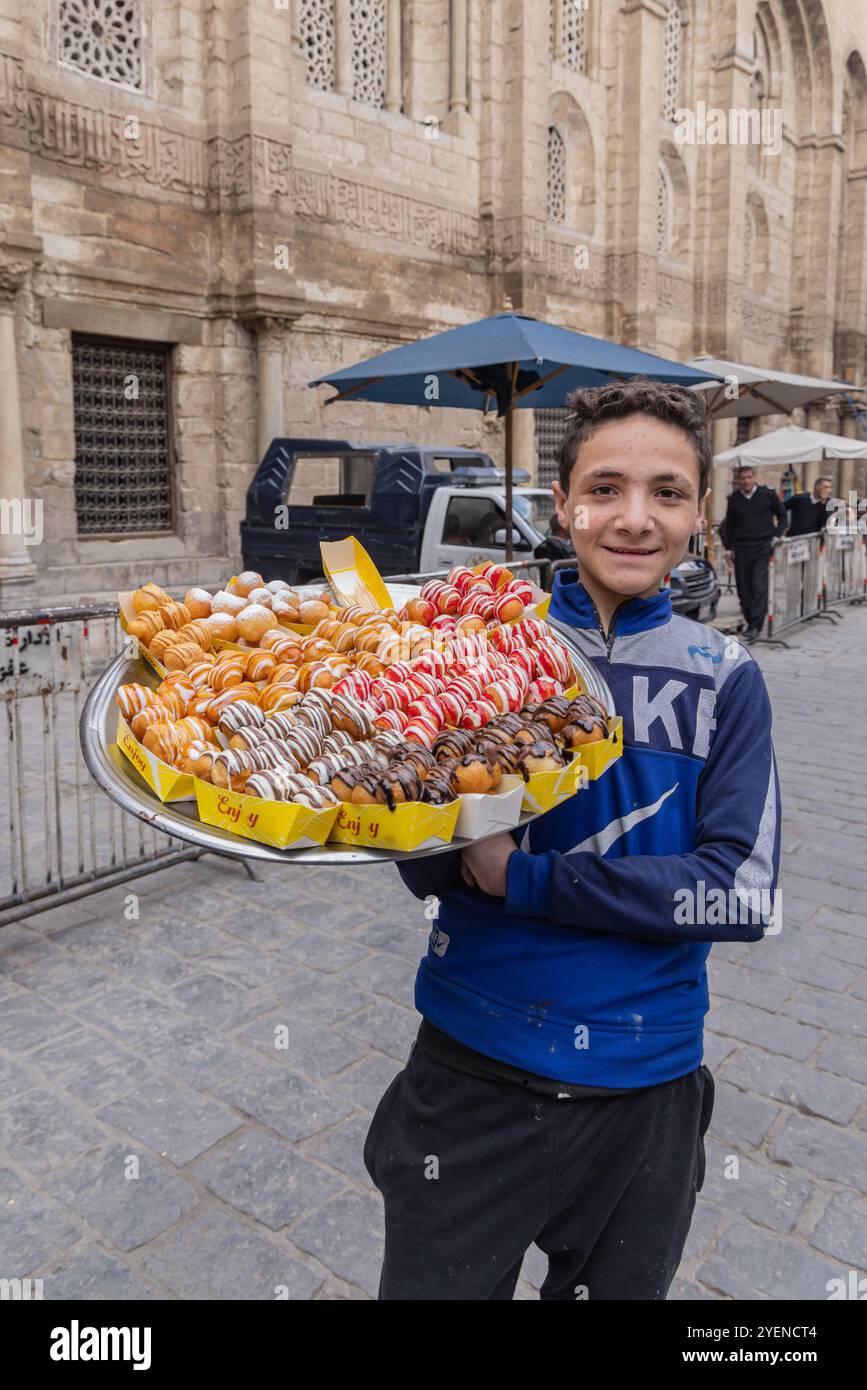Cairo, Egypt. February 22, 2023. Boy selling sweet treats at an outdoor ...