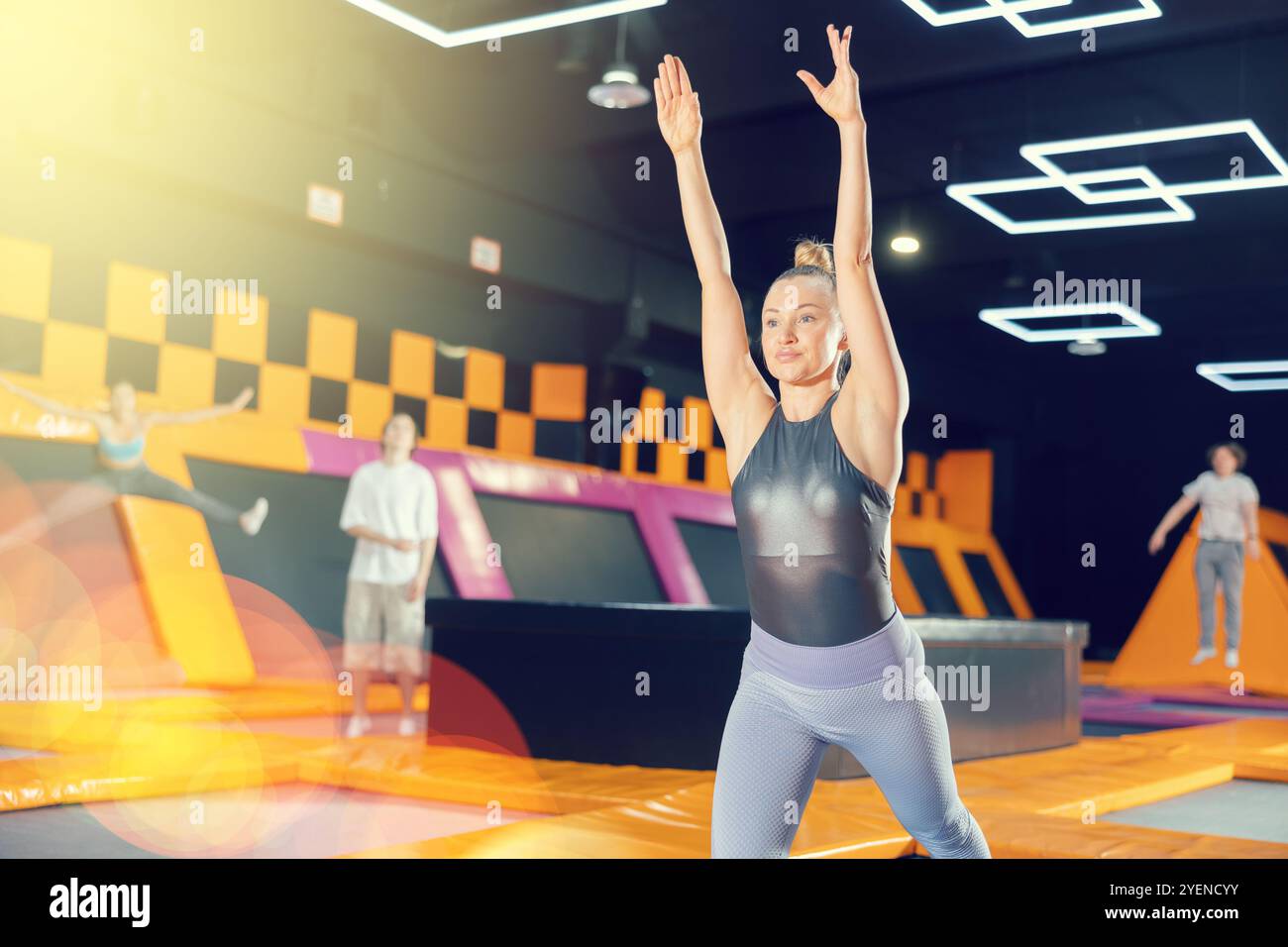 Adult woman trains jumping in trampoline center Stock Photo - Alamy