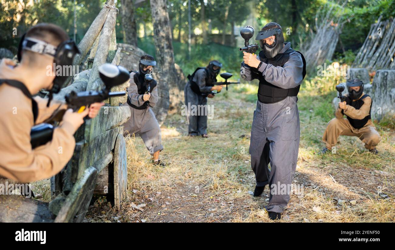 Teams facing on battlefield in outdoor paintball arena during match ...