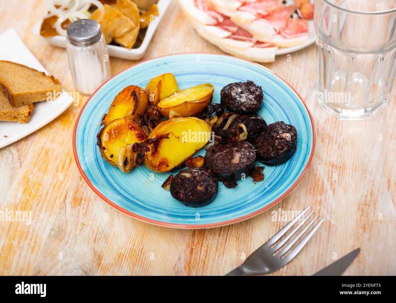 fried black pudding with crispy crust,garnished with baked potatoes in ...