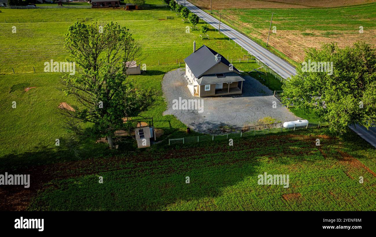 An Amish one room school house sits on a gravel area, surrounded by ...