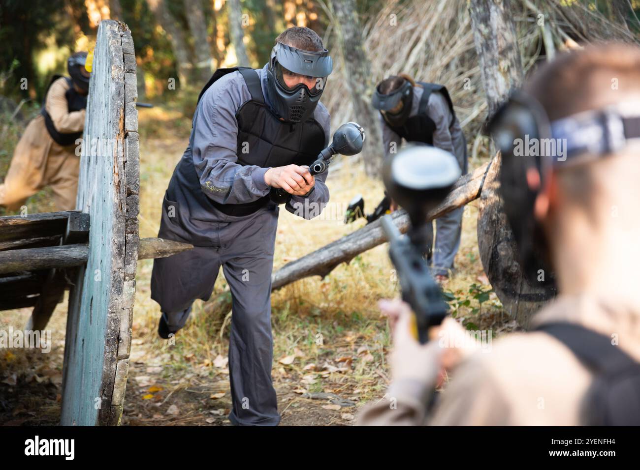 Paintball players aiming and shooting with guns at opposing team Stock ...