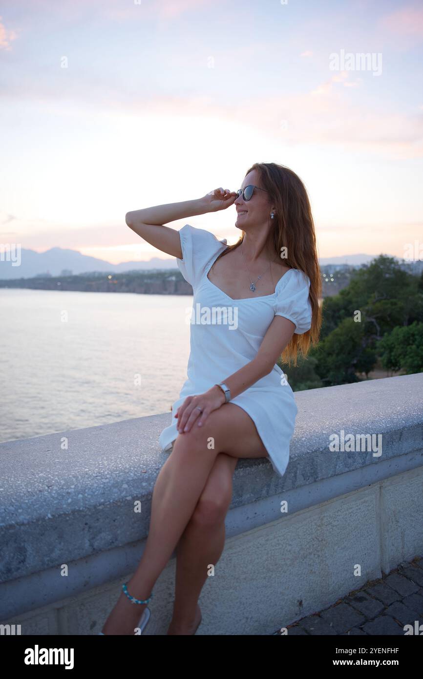 Young Woman Embracing Golden Hour by the Sea Vertical Shoot Stock Photo ...