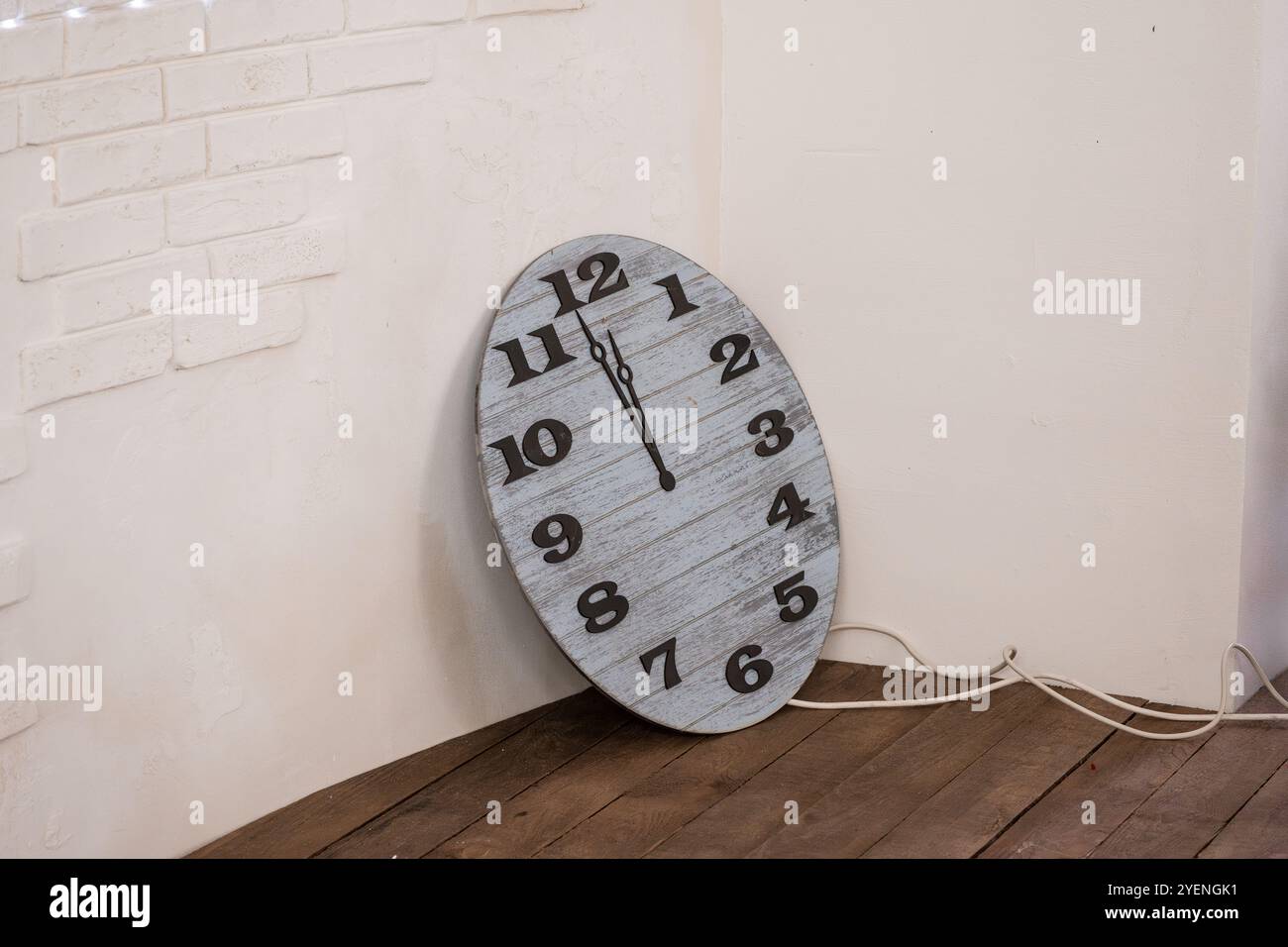 Wall Clock Leaning Against a Rustic White Brick Wall Stock Photo - Alamy