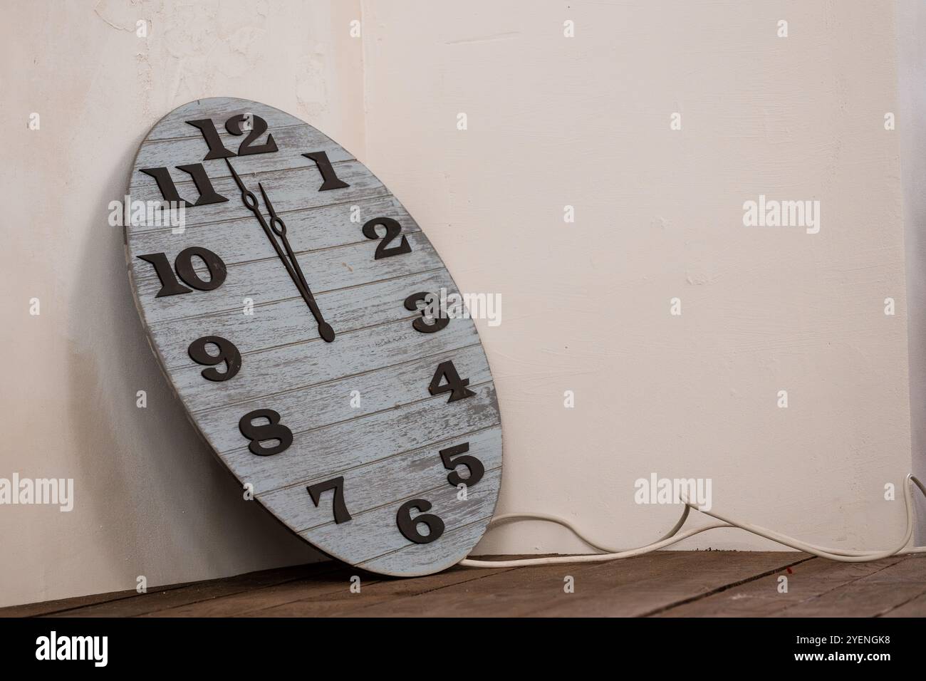 Vintage Rustic Wall Clock Leaning Against a Wall Stock Photo - Alamy