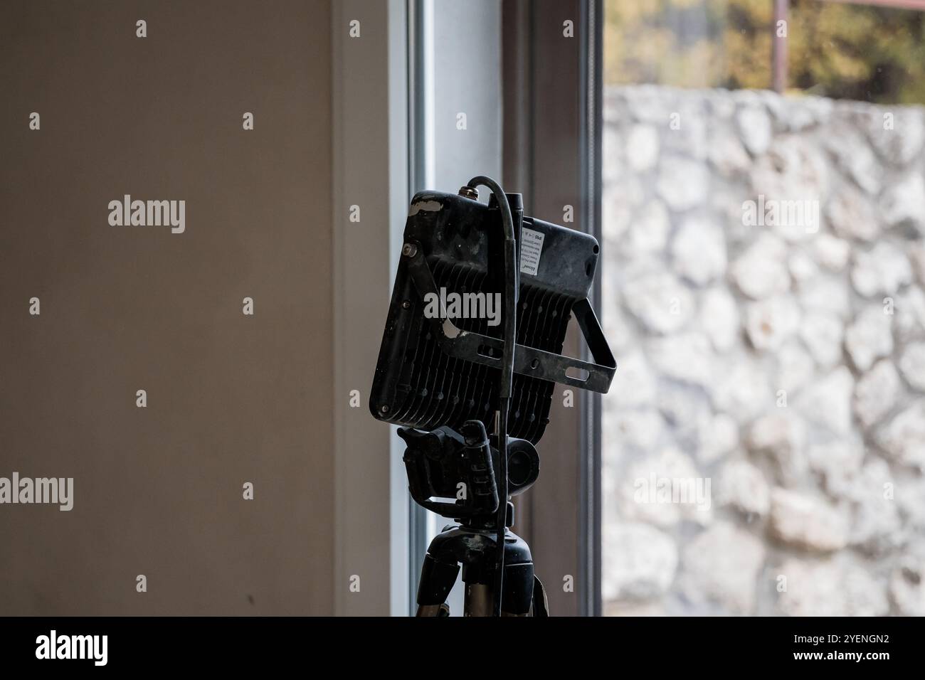 Spotlight on a Tripod Next to a Window in a Stone Wall Setting Stock ...