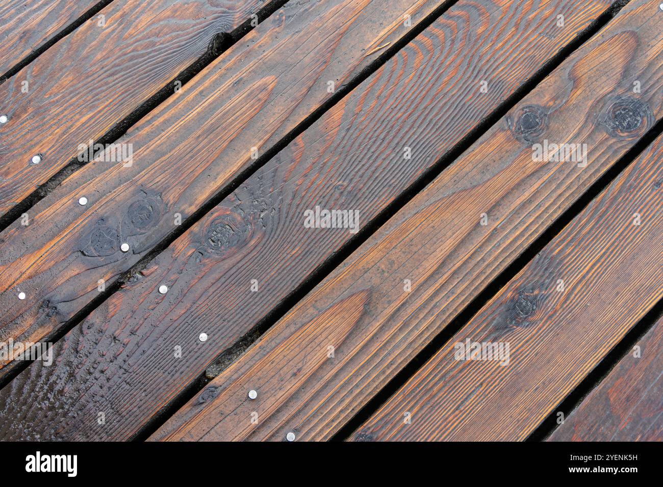 Top view of a dark wood boardwalk floor with rustic grains and knots ...