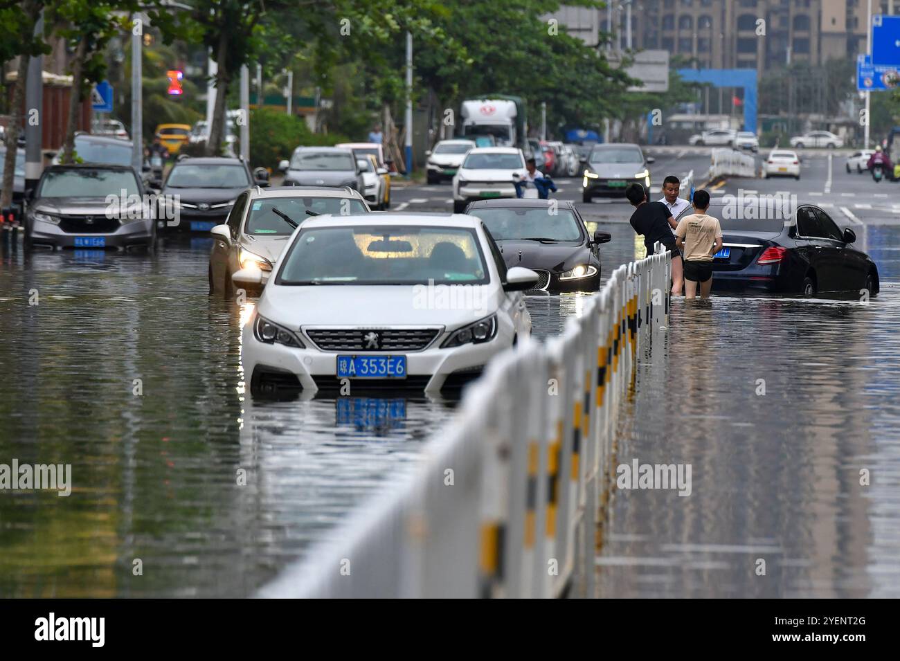 Vehicles are stopped at a waterlogged road in Haikou City, South China ...