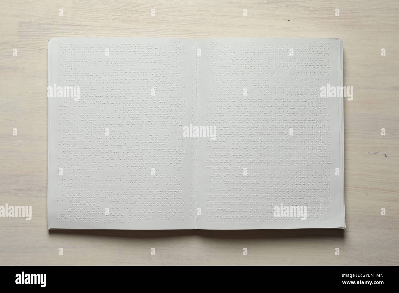 Book with Braille text on wooden table, top view. Education and leisure ...