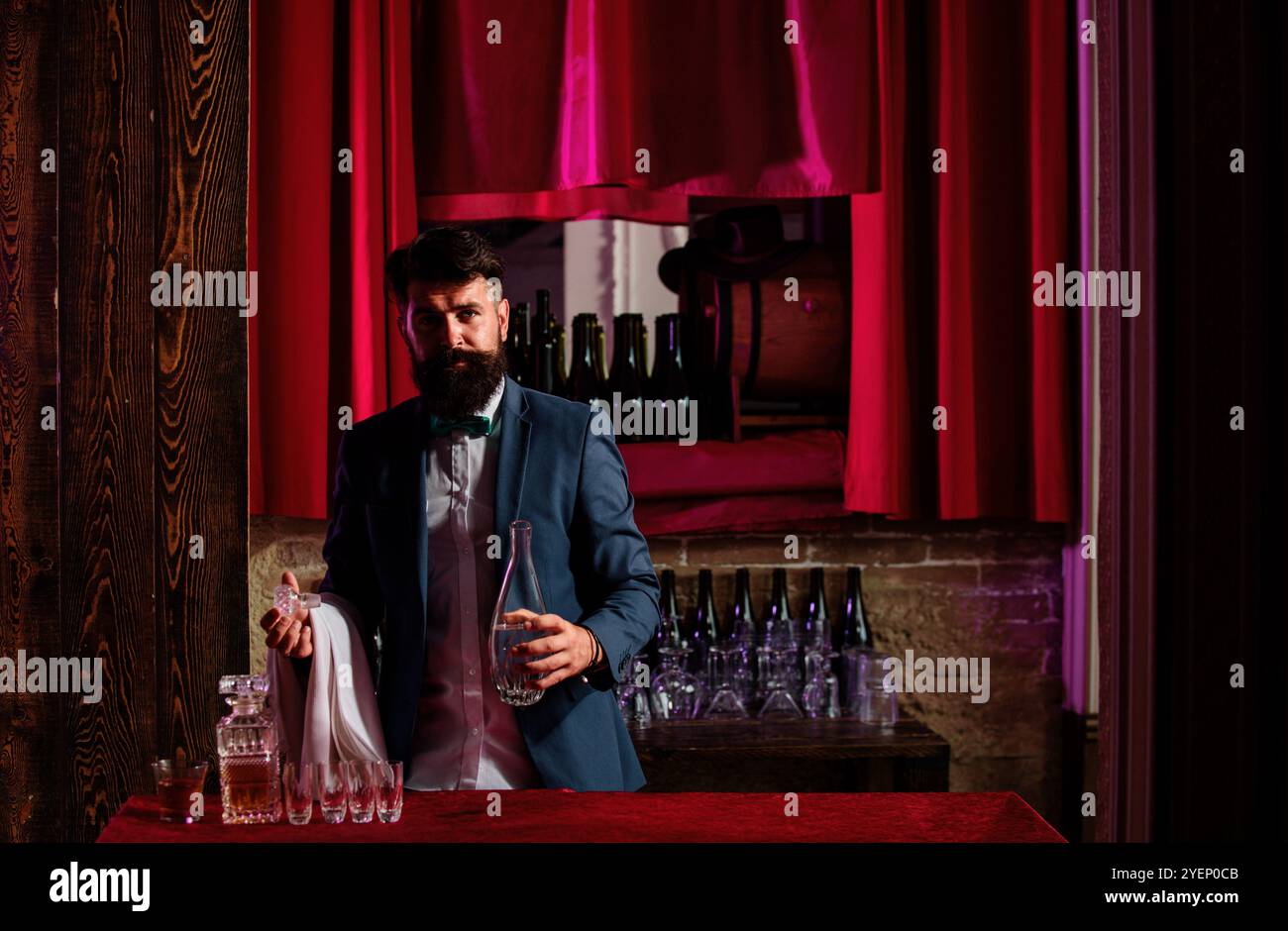 Waiter bartender. Handsome bearded barman leaning on bar counter ...