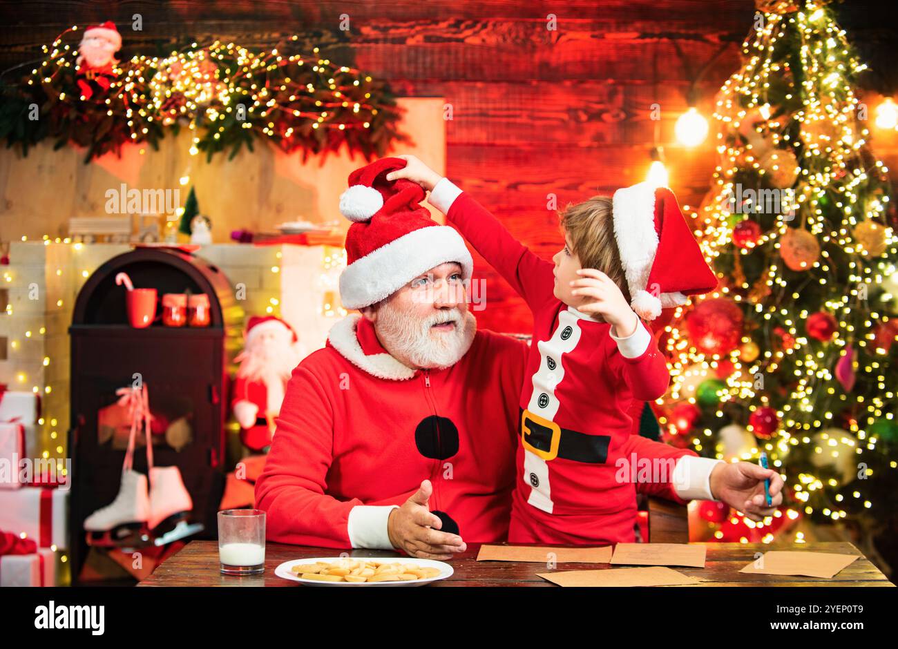 Christmas helper child writing letter to Santa Claus letter in red hat ...