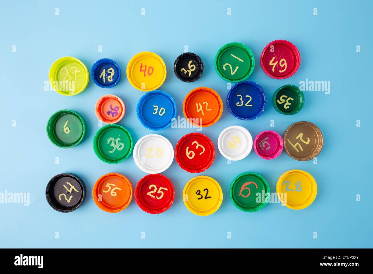 Multiplication problems on colorful bottle caps arranged on blue ...