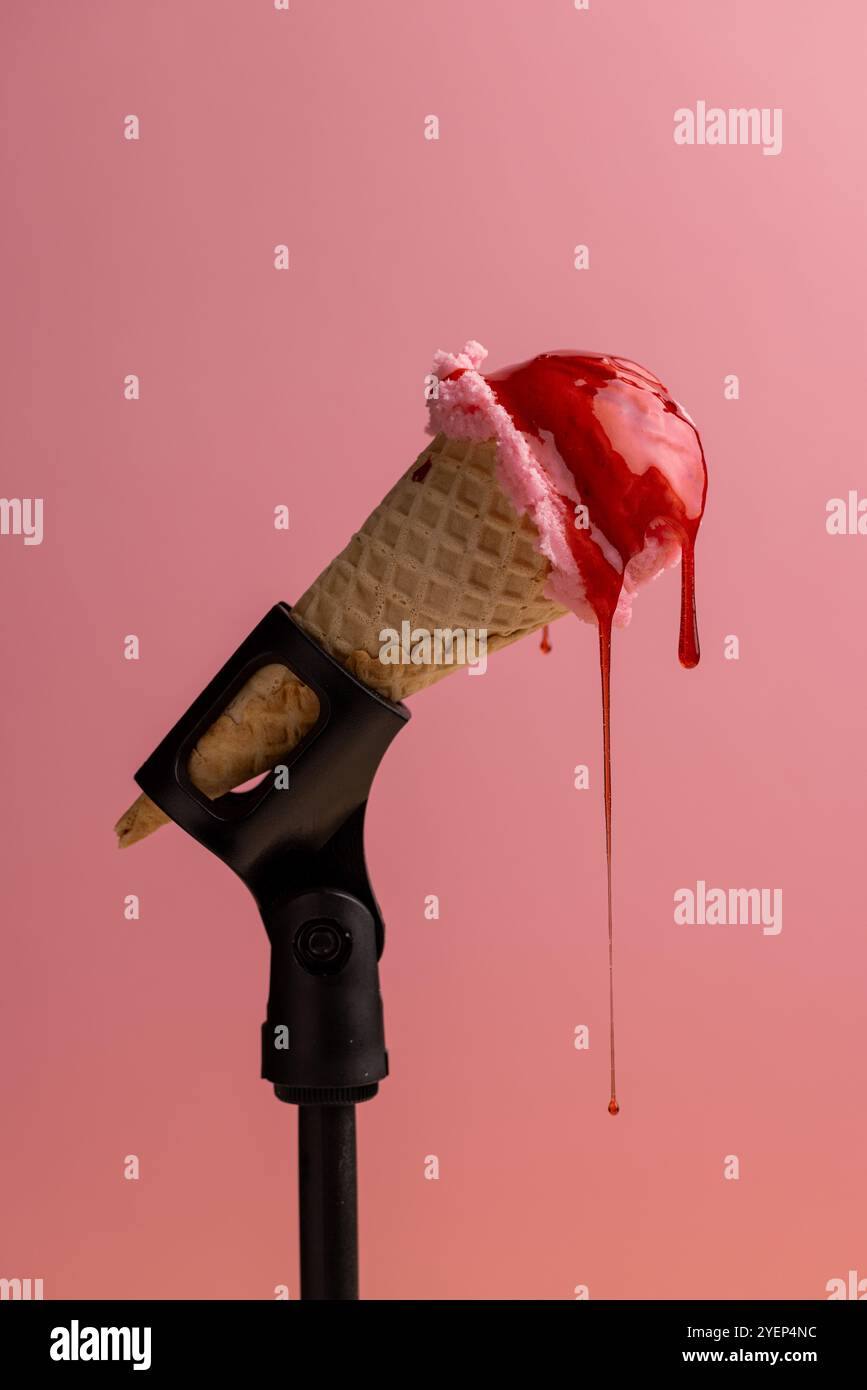 A ball of ice cream in a cone in a microphone stand with dripping drops ...