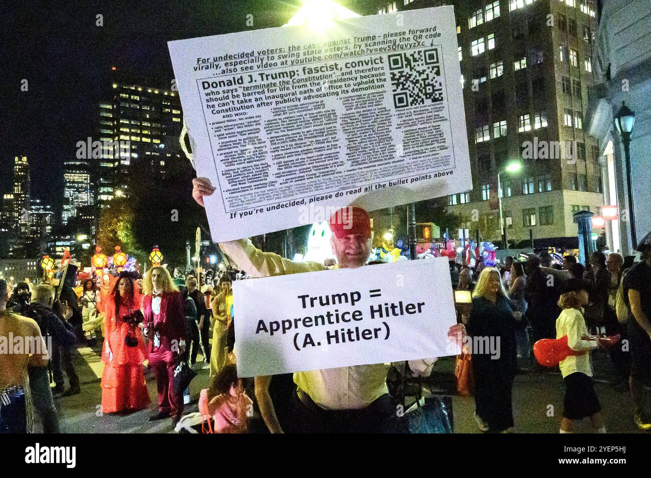 New York, USA. 31st Oct, 2024. A reveller displays signs comparing ...