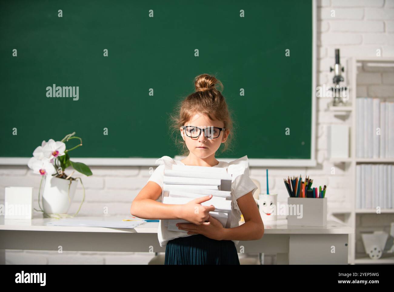 Portrait of serious pupil girl of primary school study. Nerd school ...