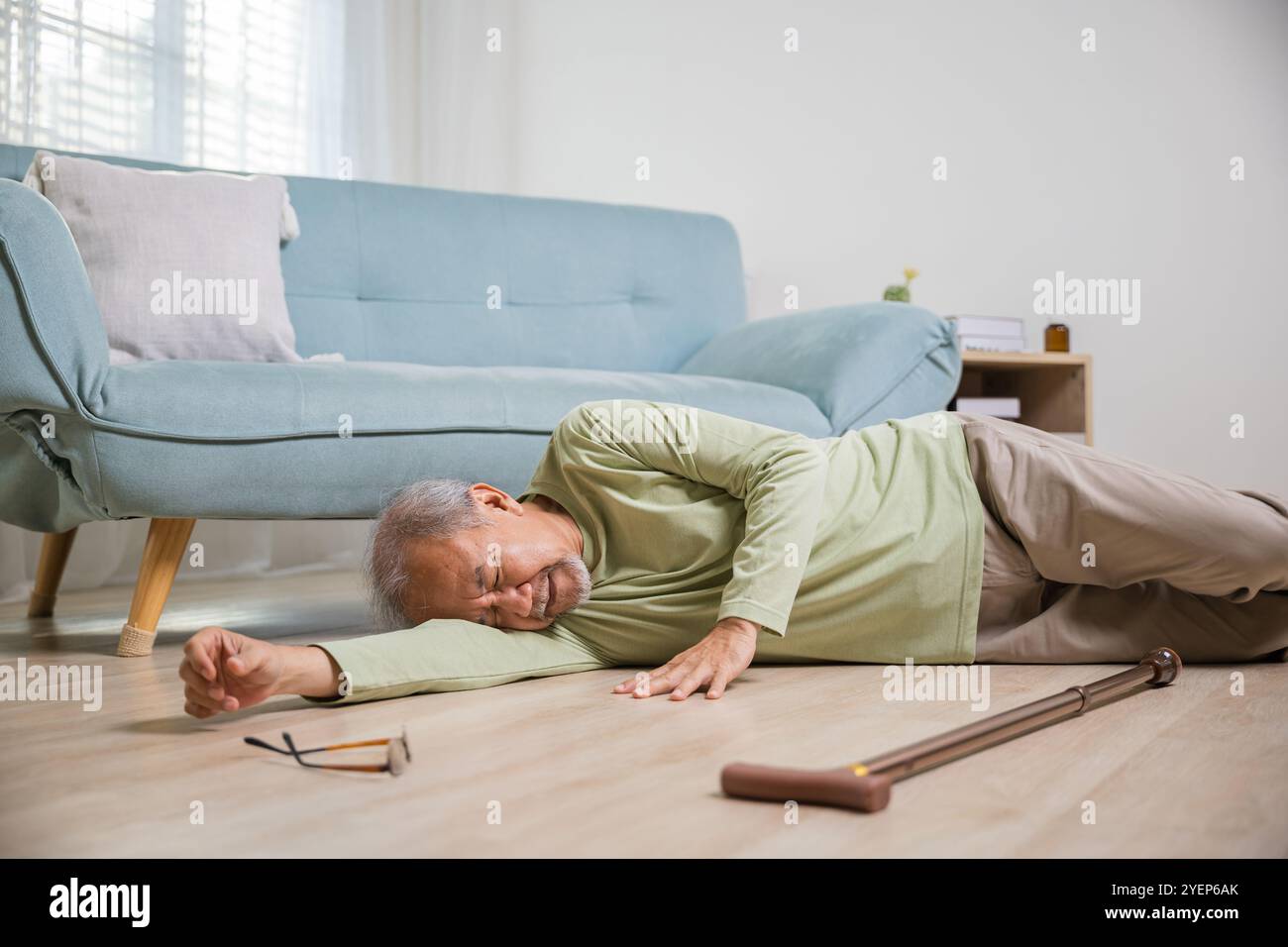 Asian old man lying on floor after falling down with wooden walking ...