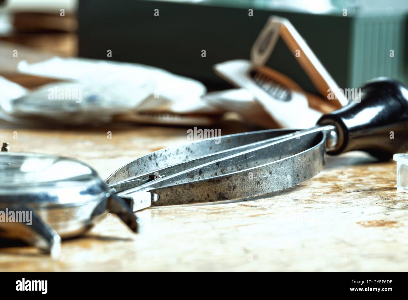 watchmaker’s bench holds a metallic tool, weathered but still ...