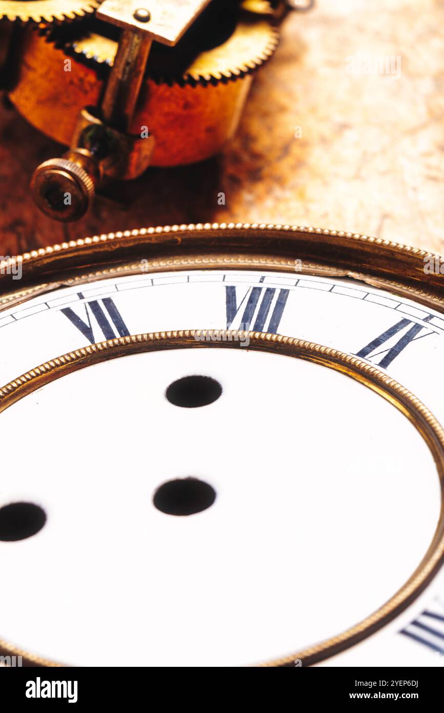 Antique clock dial with Roman numerals and gold-edged frame sits on a ...