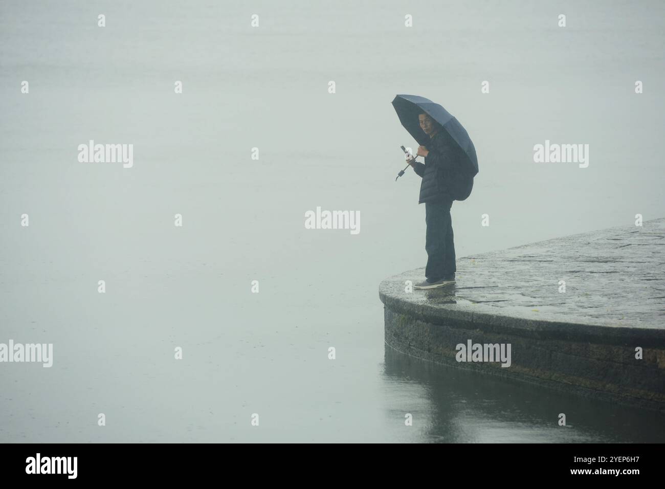HANGZHOU, CHINA - NOVEMBER 1, 2024 - A tourist braves strong winds and ...