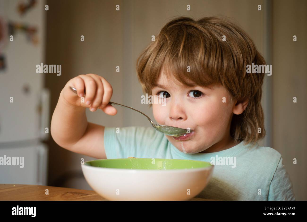 Cute child eating breakfast at home. Parenthood. Baby eating. Young kid ...