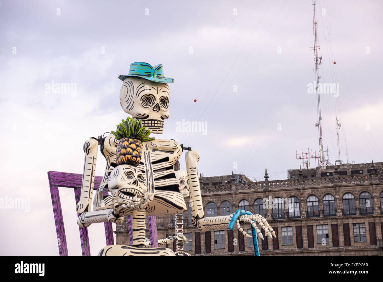 A large skeleton figure holding a smaller skull and a pineapple ...
