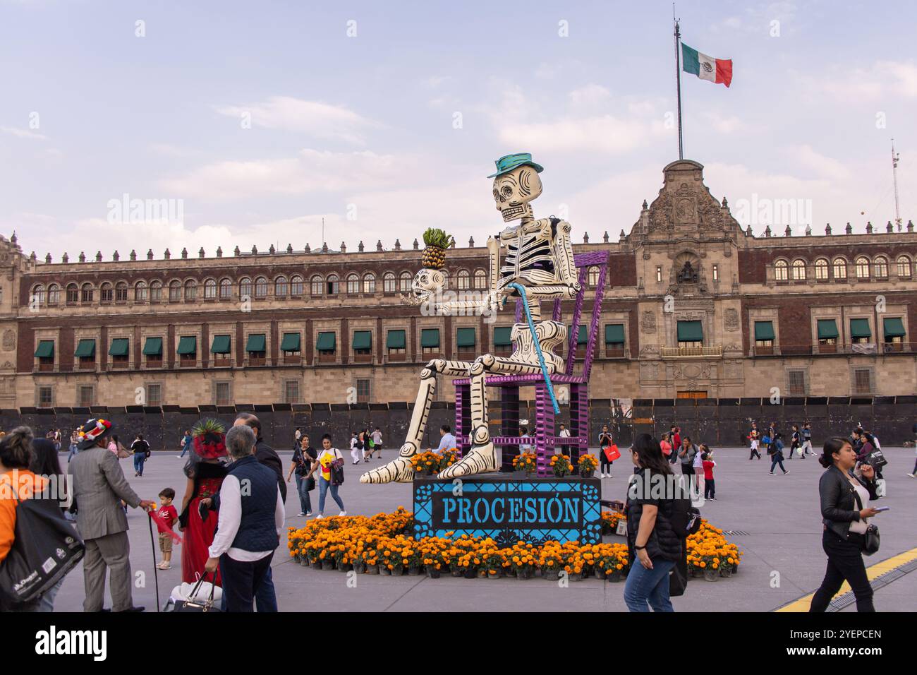 A giant skeleton sculpture seated in a decorated chair with marigolds ...
