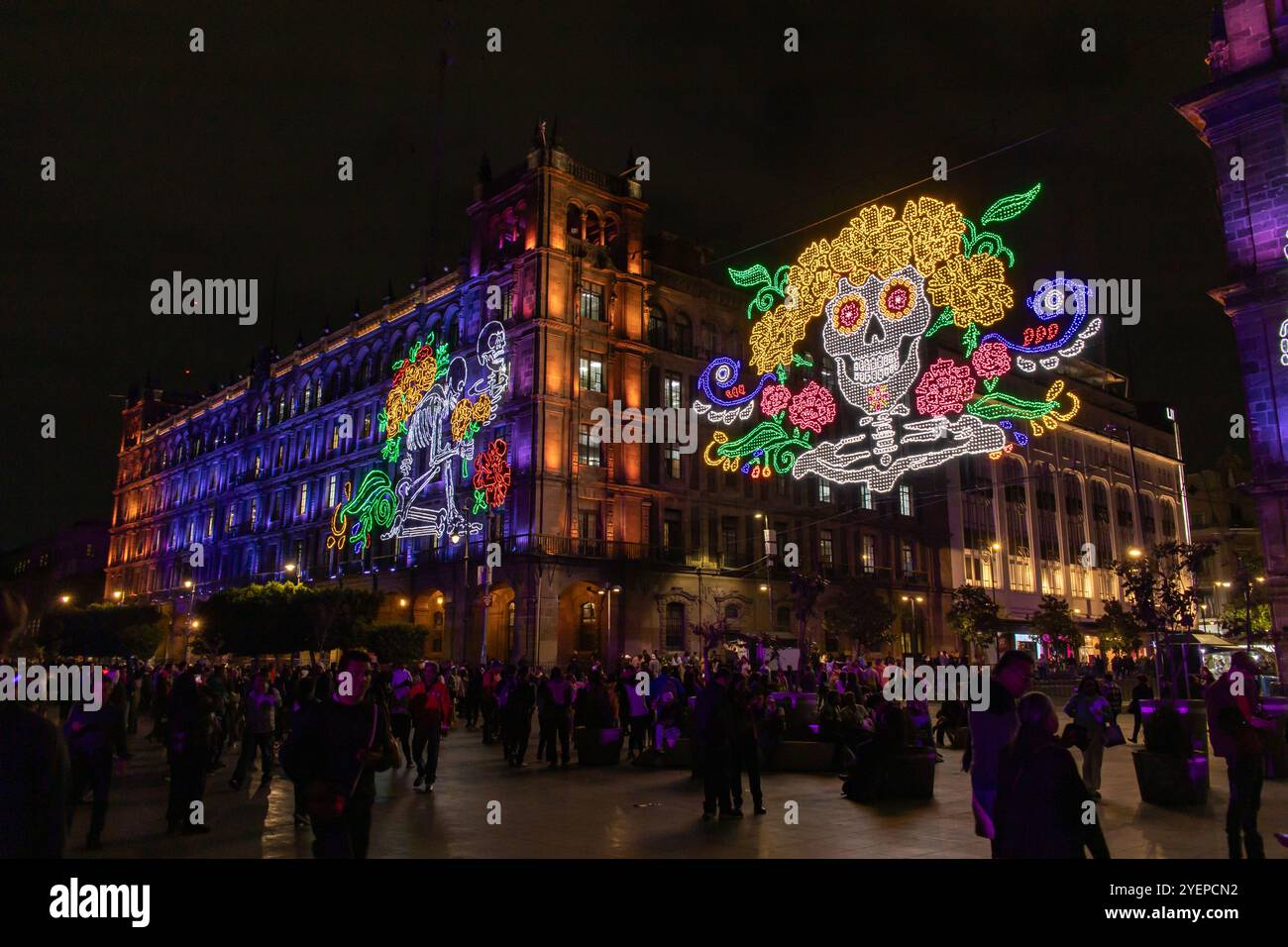 Brightly lit Day of the Dead decorations featuring skulls, flowers, and ...