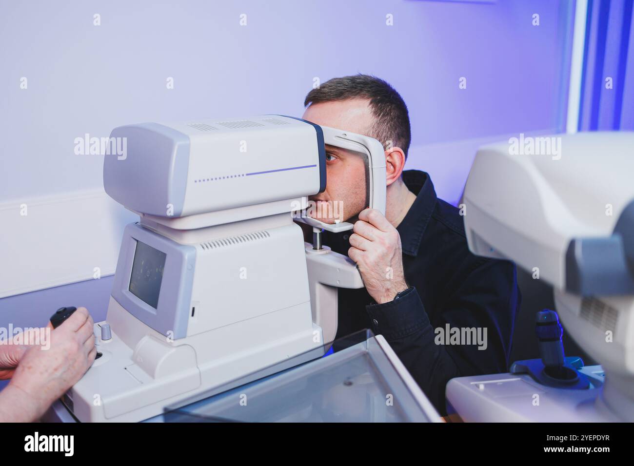 Checking a man's vision with a modern microscope at an appointment with ...