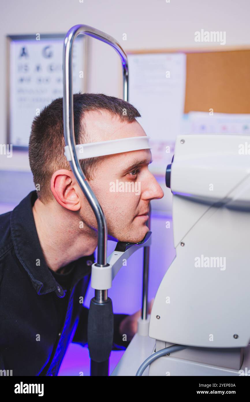 Checking a man's vision with a modern microscope at an appointment with ...