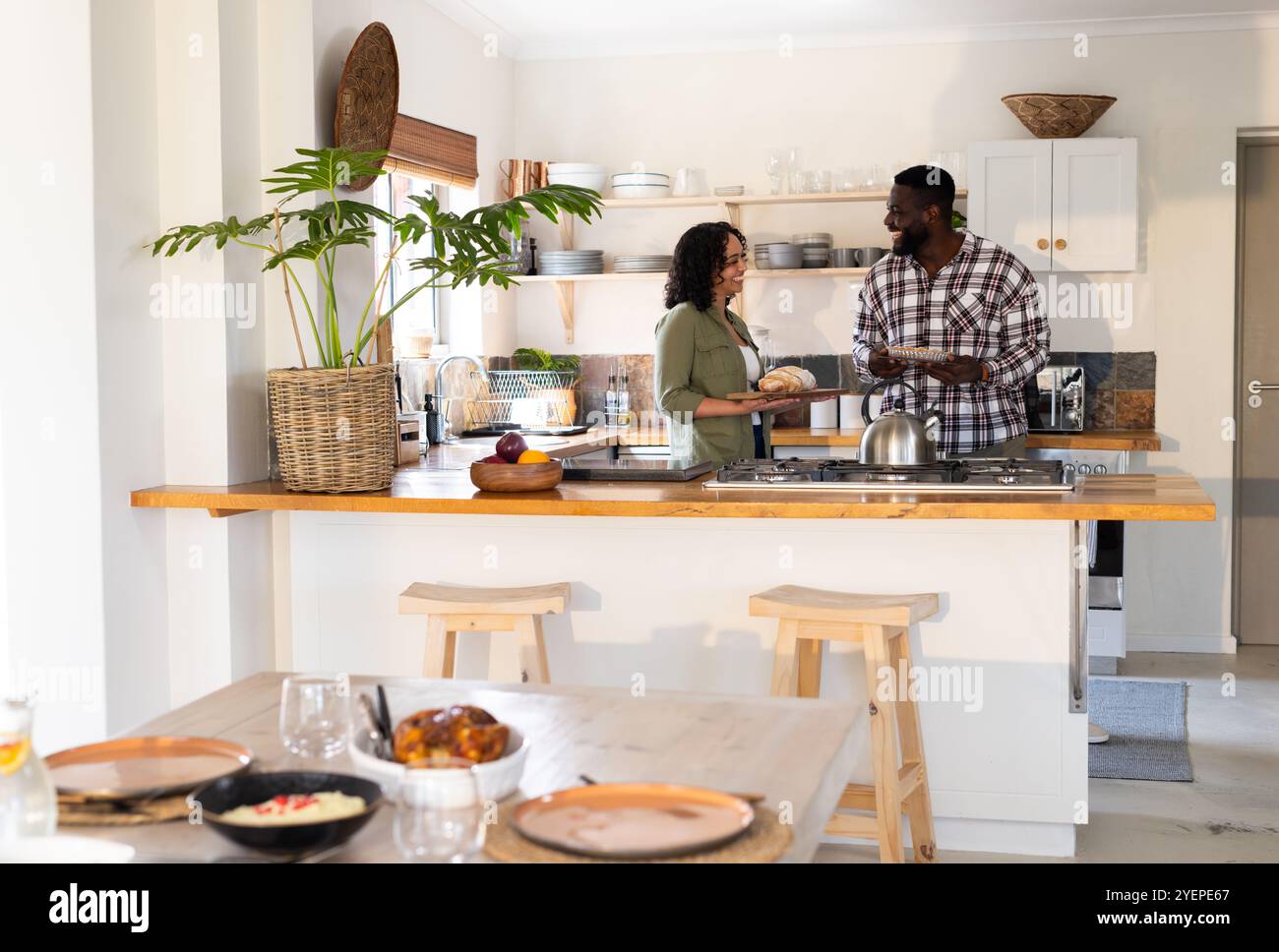 multiracial couple preparing Thanksgiving meal together in cozy kitchen ...