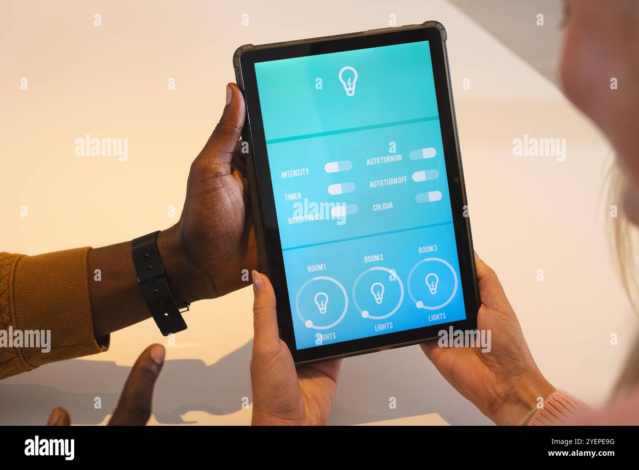 multiracial couple using tablet to control smart home lighting system ...