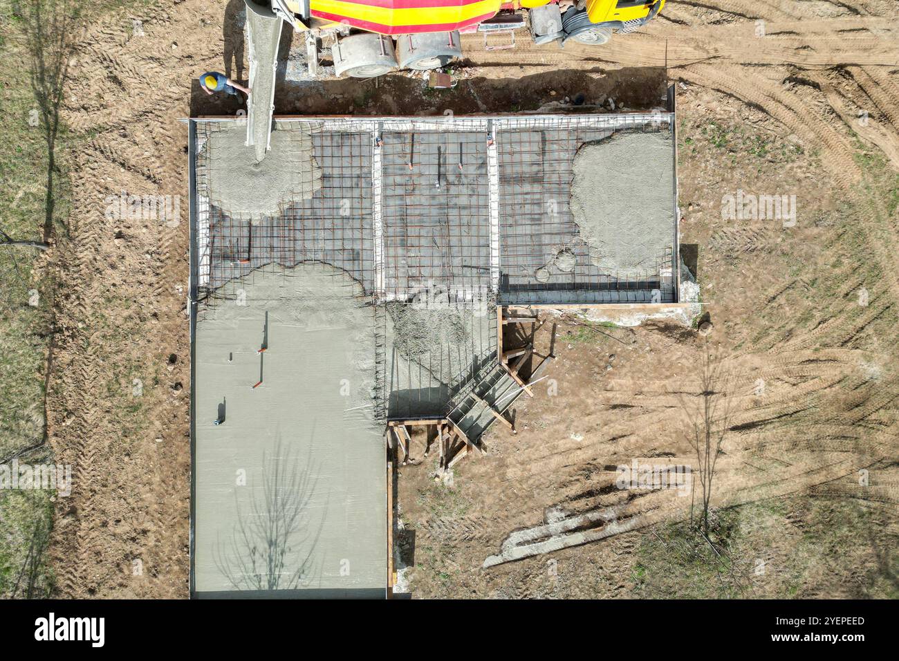 Construction site, aerial view, worker builder pouring concrete from a ...