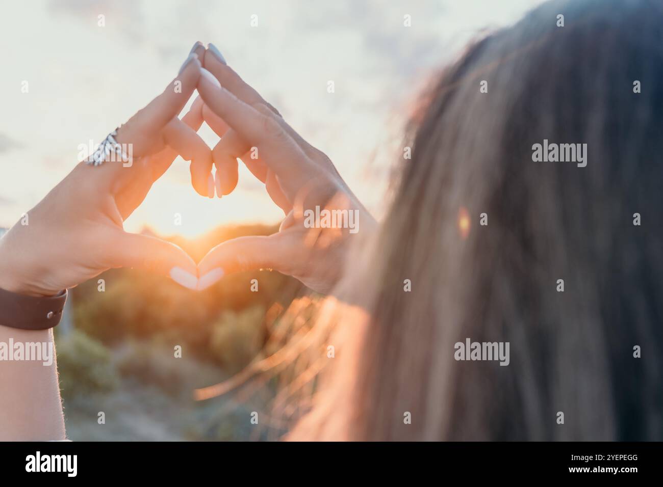 Sunset Heart Hands Woman - A woman forms a heart shape with her hands ...