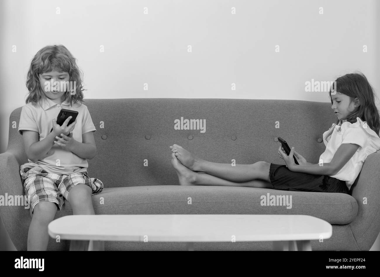 Two kids alone with phone at home. Little cute kids playing smartphone ...