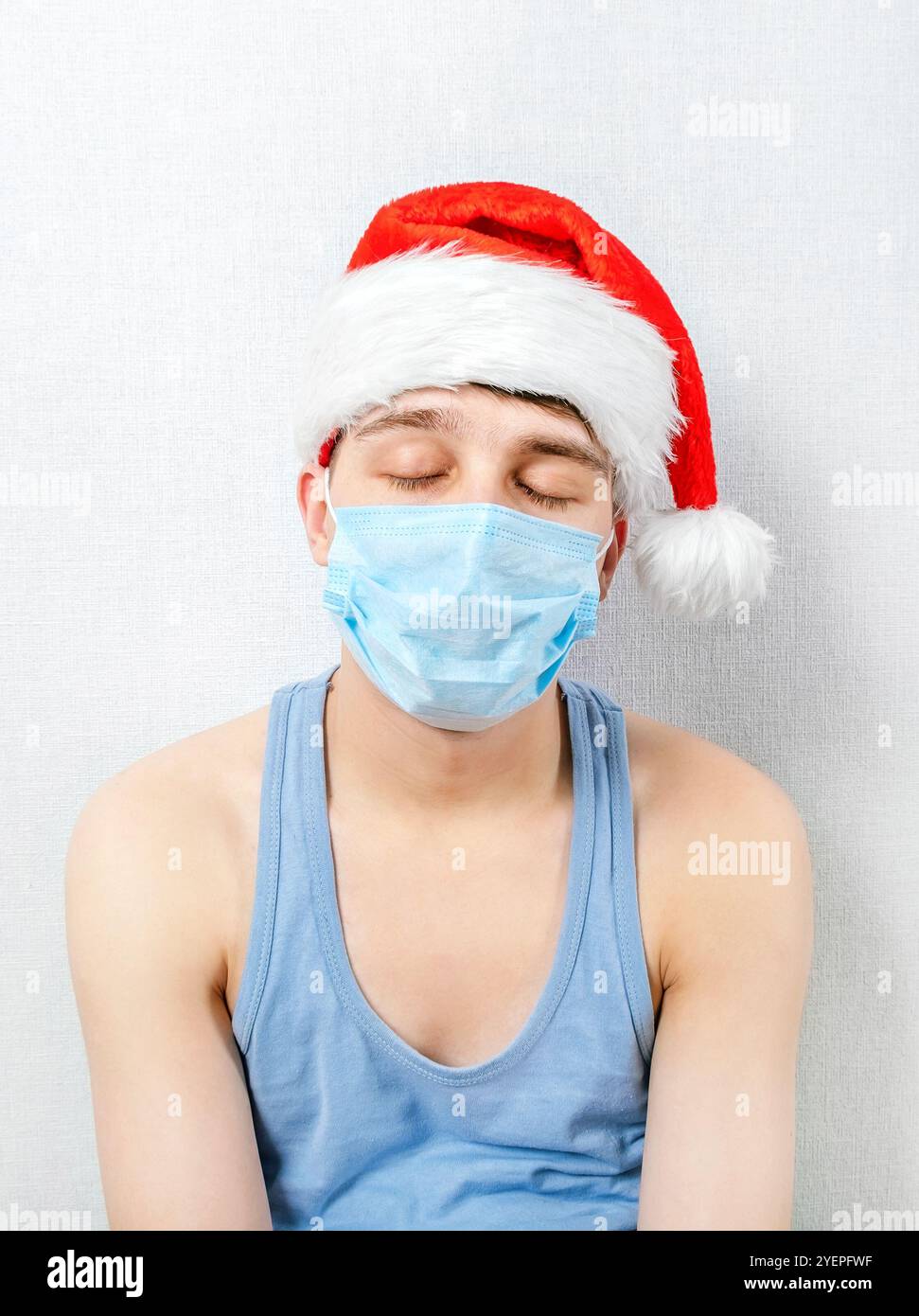 Sad and Sick Young Man in Santa Hat and Flu Mask by the Wall Stock ...
