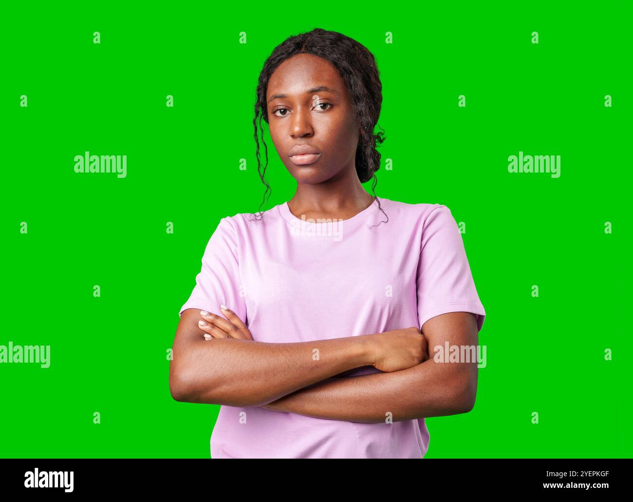 Young woman with an expression of contemplation poses against a bright ...