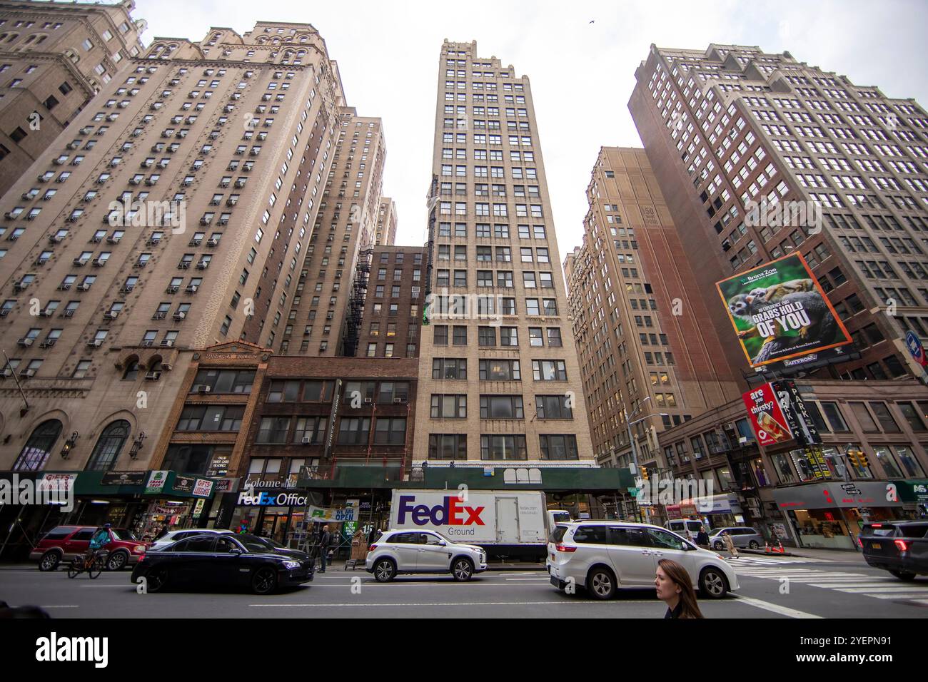 The image shows a busy New York City street with towering buildings ...